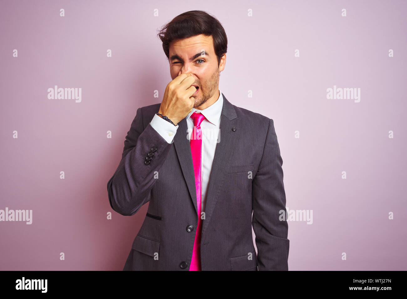 Young handsome businessman wearing suit and tie standing over isolated ...