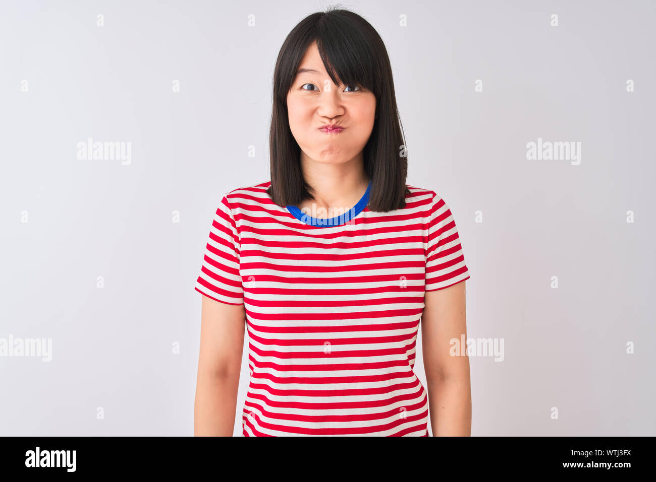 Young beautiful chinese woman wearing red striped t-shirt over isolated ...