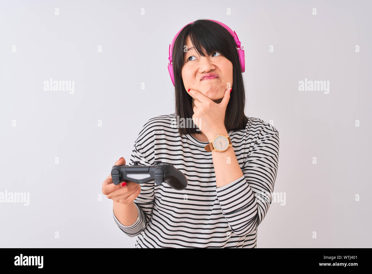Chinese gamer woman playing video game using headphones over isolated ...
