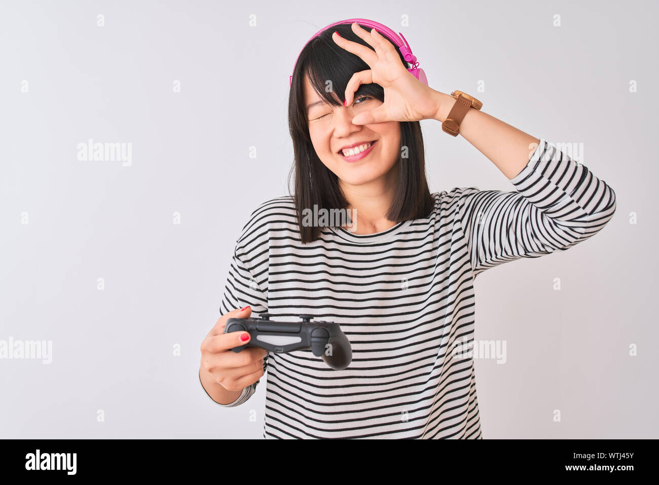 Chinese gamer woman playing video game using headphones over isolated ...