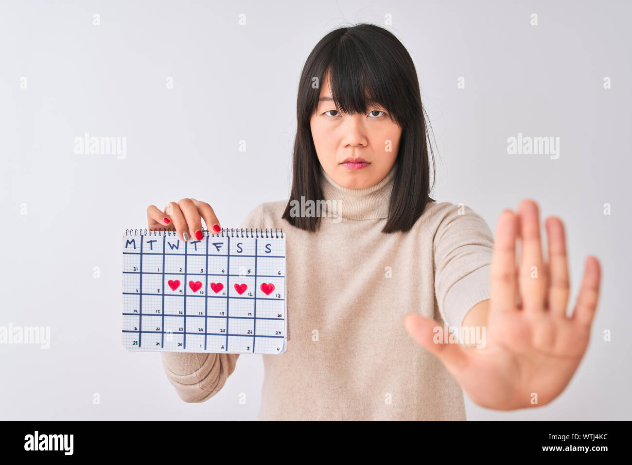 Young beautiful Chinese woman holding menstruation calendar over ...