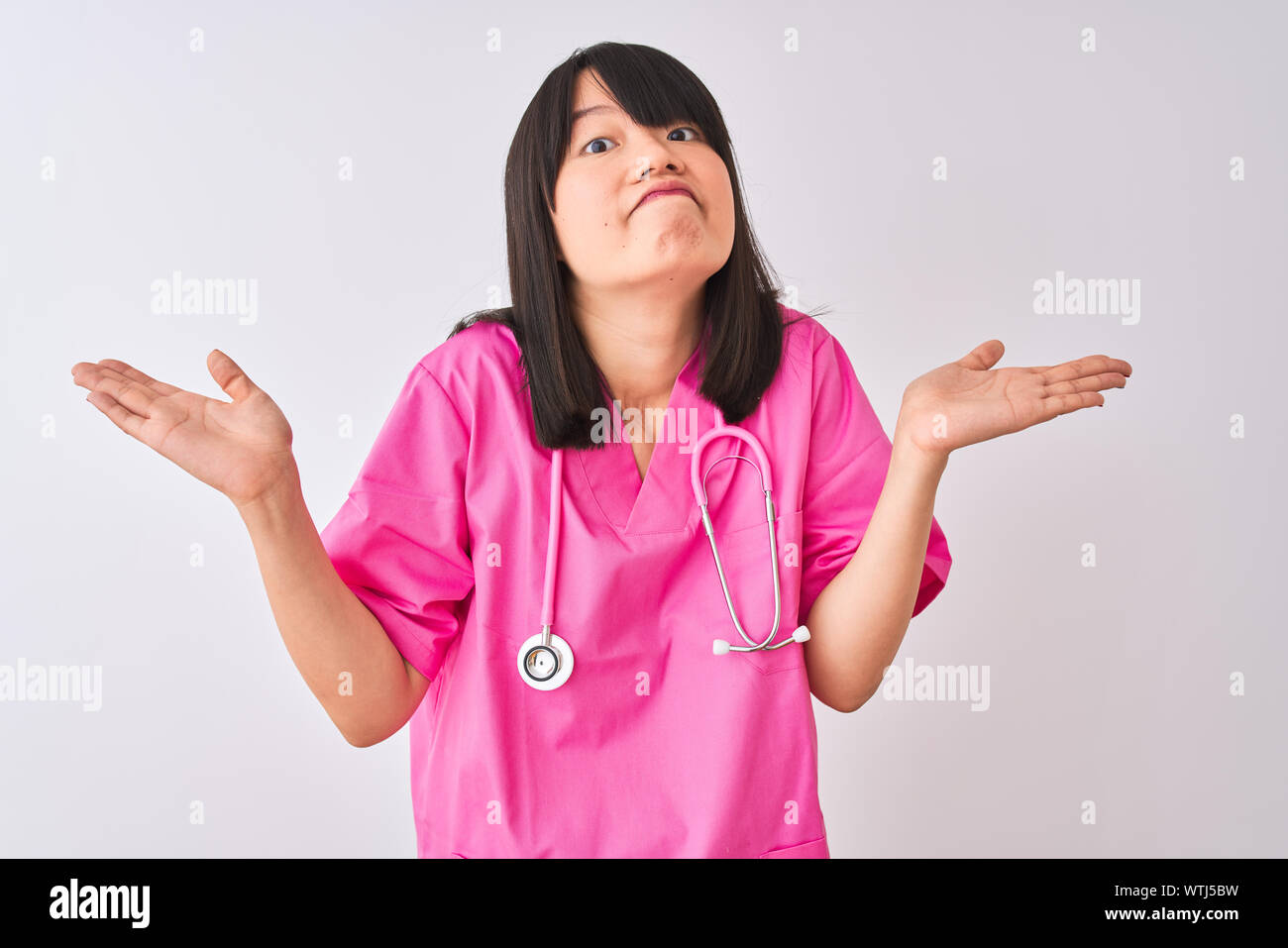 Young beautiful Chinese nurse woman wearing stethoscope over isolated ...