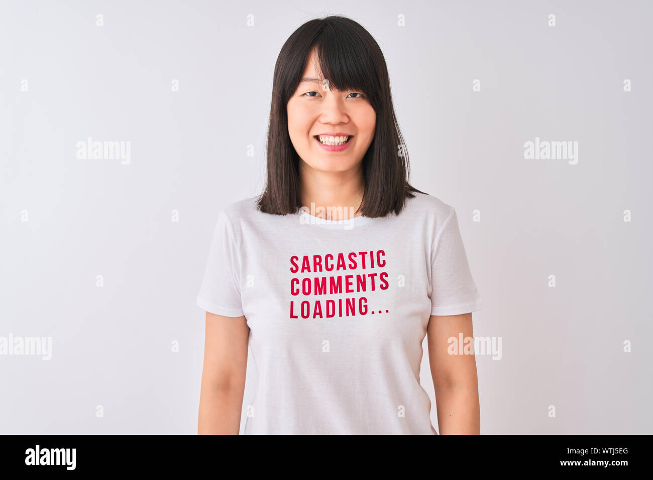 Young beautiful Chinese woman wearing fanny t-shirt over isolated white ...