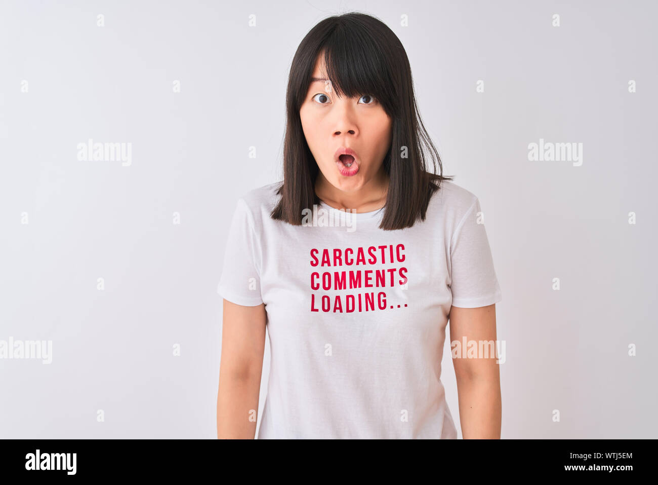 Young beautiful Chinese woman wearing fanny t-shirt over isolated white ...