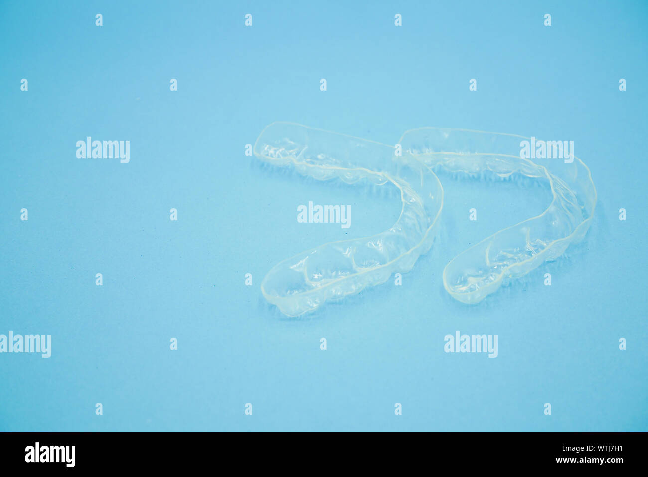 clear plastic retainer teeth that isolated on blue sky background. it's ...