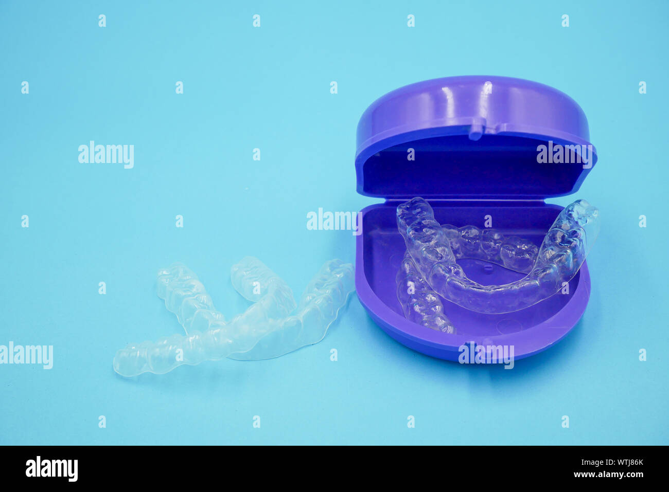 clear plastic retainer teeth in the box set isolated on blue sky ...