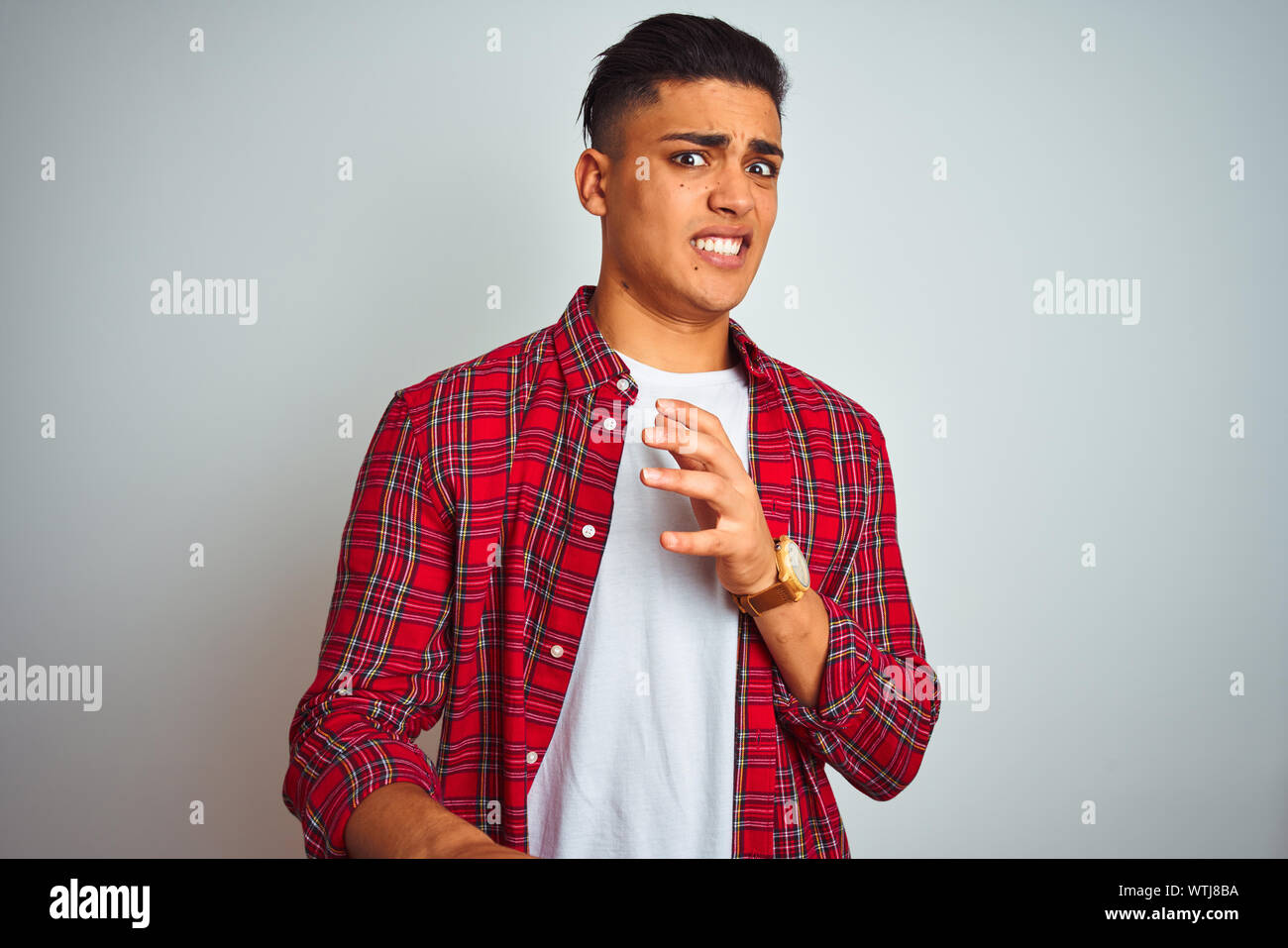 Young brazilian man wearing red shirt standing over isolated white ...