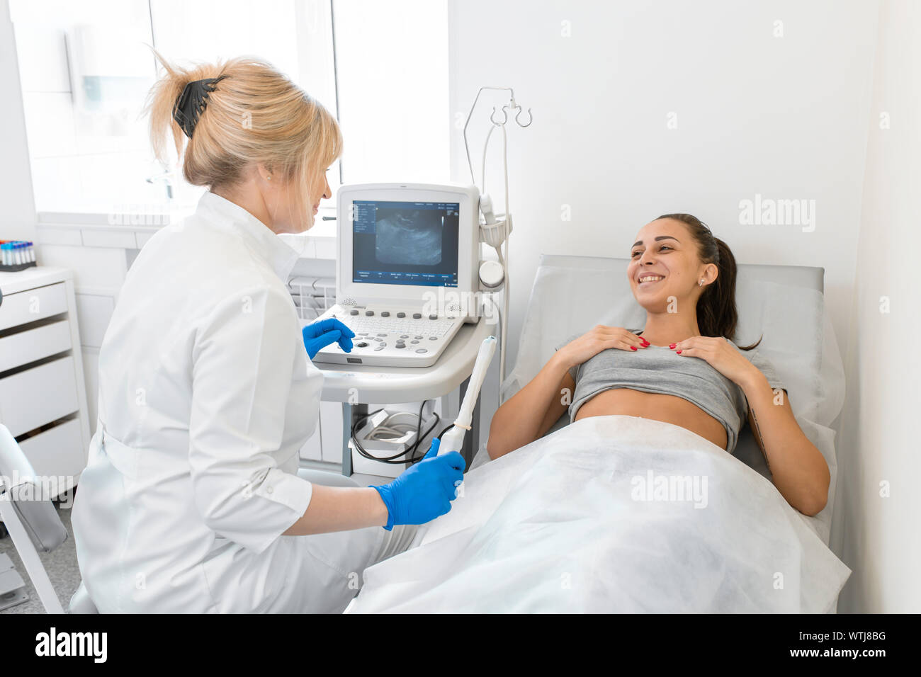 The gynecologist sets up the ultrasound machine and explains to the ...