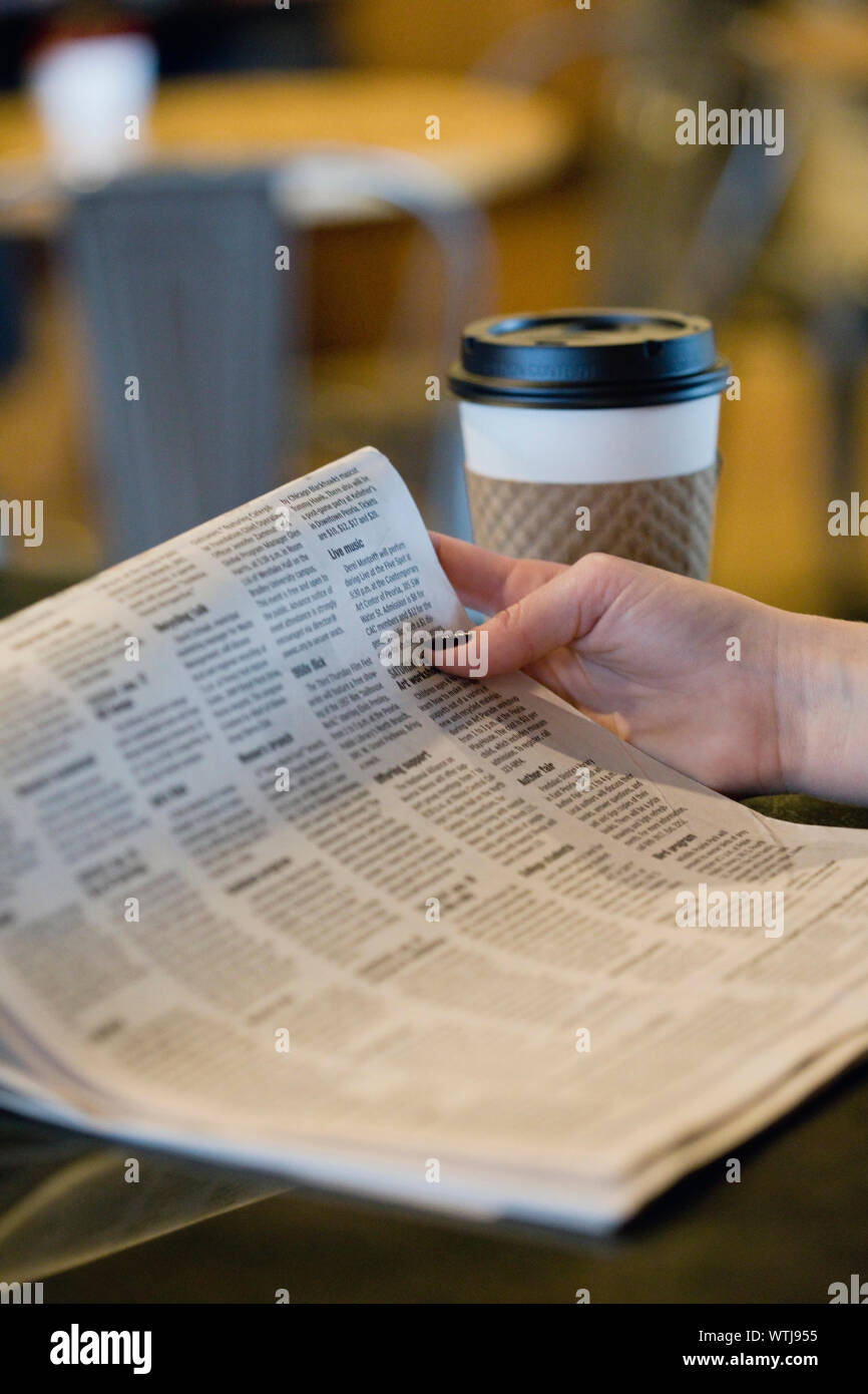 Female hand holding newspaper Stock Photo - Alamy