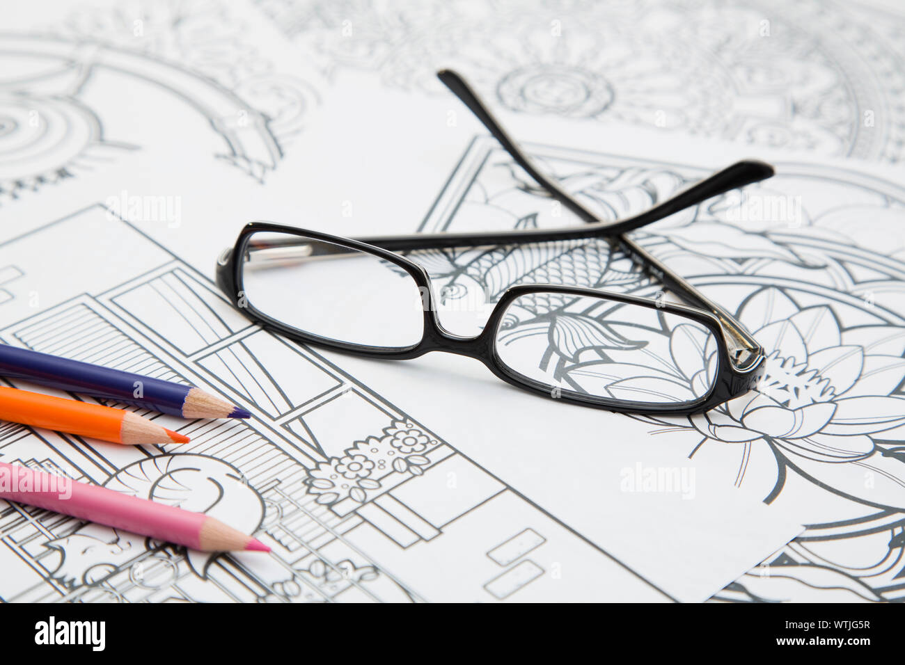 Eyeglasses and colored pencils on coloring book page Stock Photo - Alamy