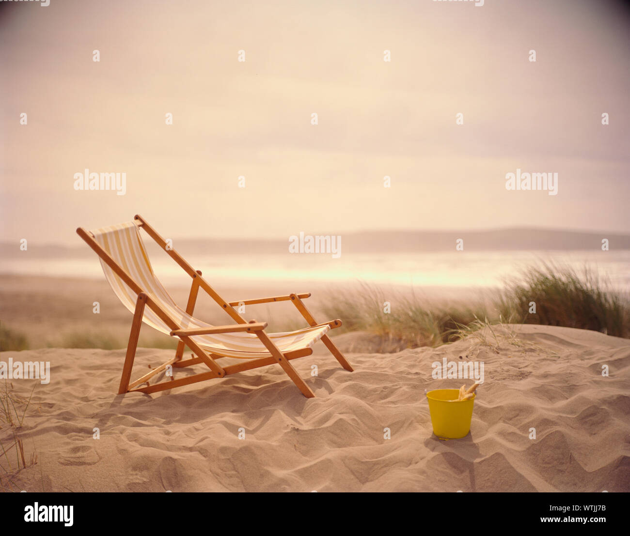 Side view of a folding chair on an isolated beach Stock Photo - Alamy