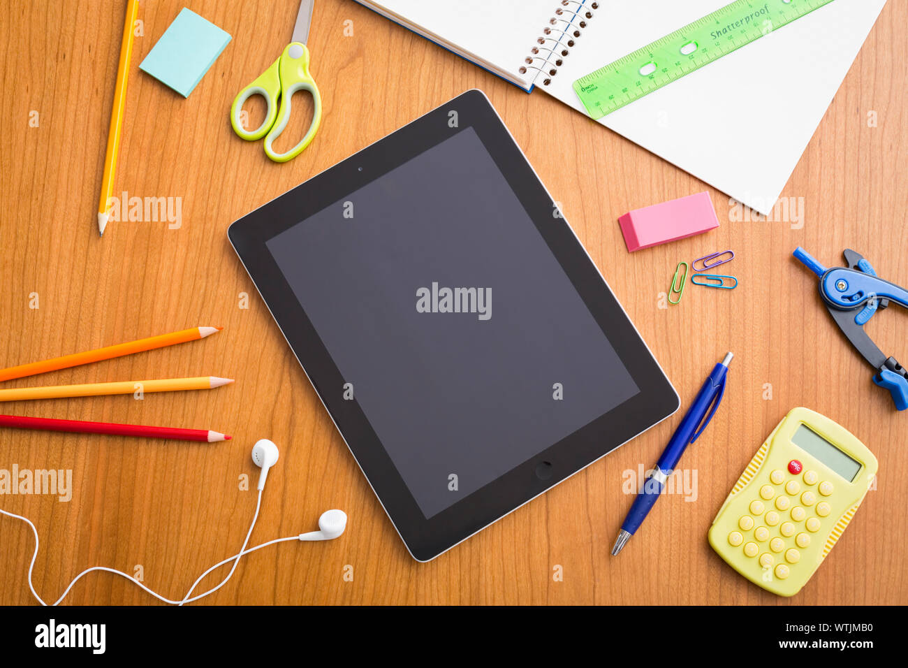 Digital tablet and school supplies on desk Stock Photo - Alamy