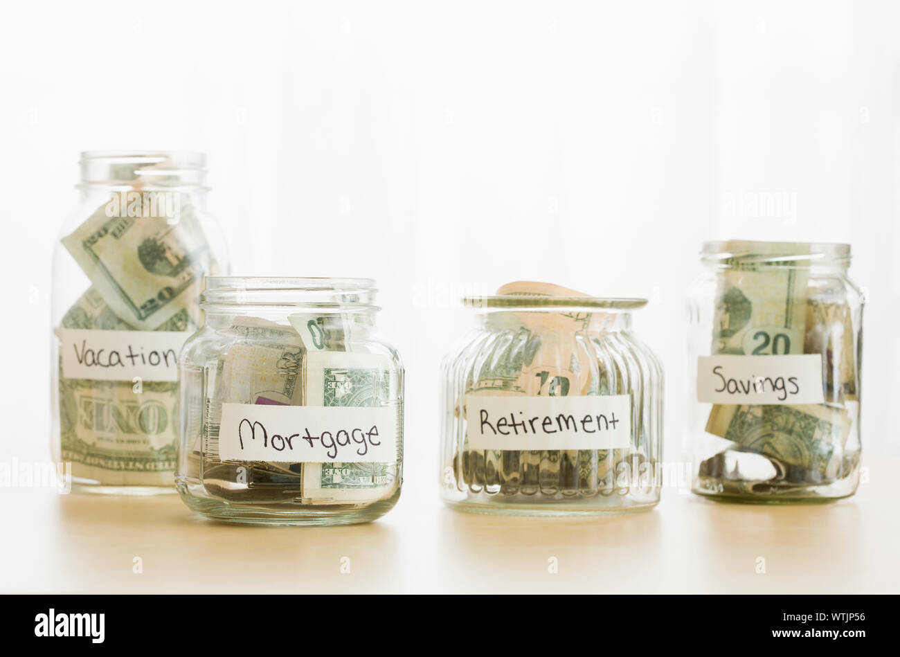 Jars with various labels filled with US dollars Stock Photo - Alamy