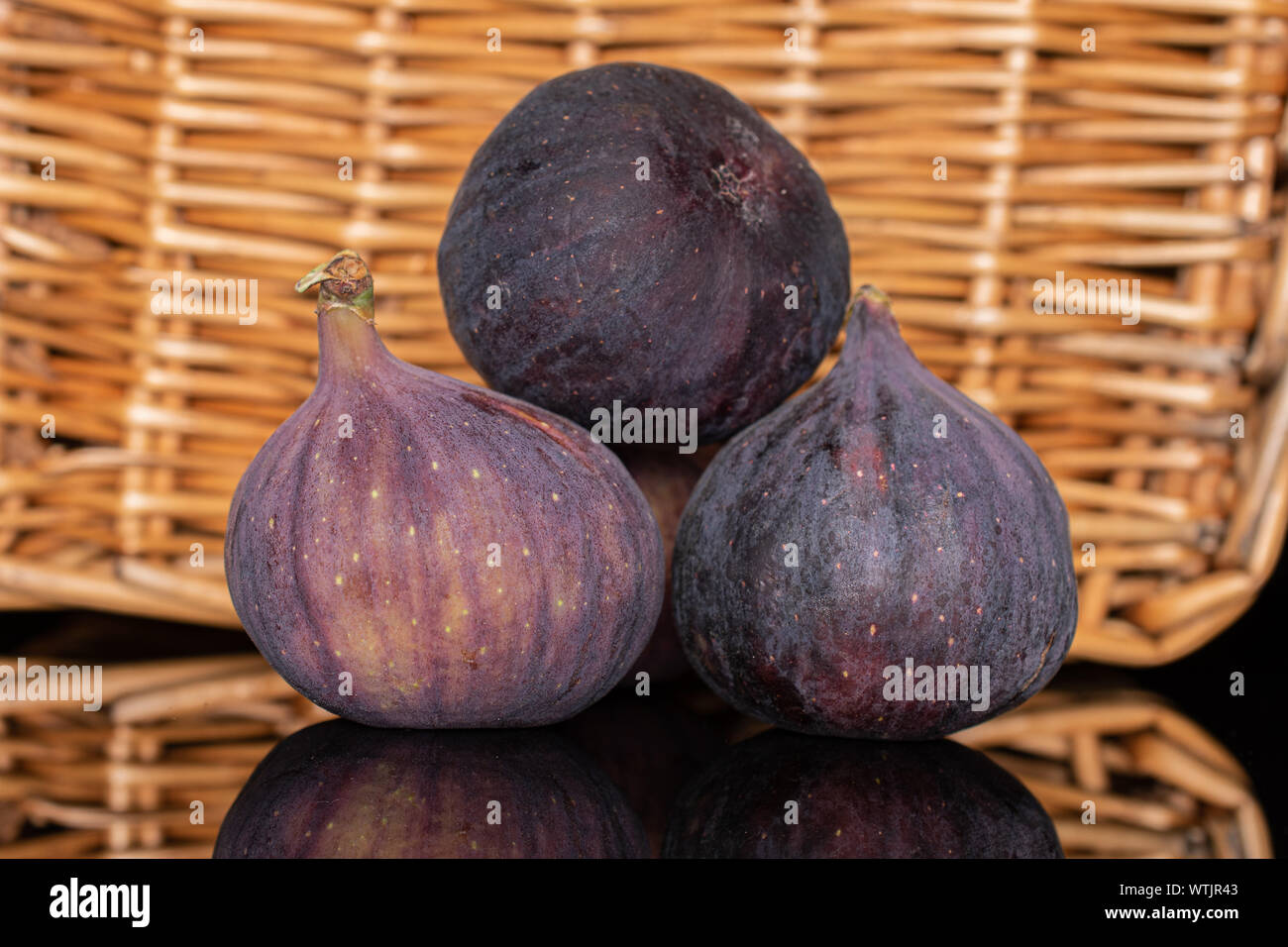 Group of three whole fresh fig fruit with braided rattan behind Stock ...