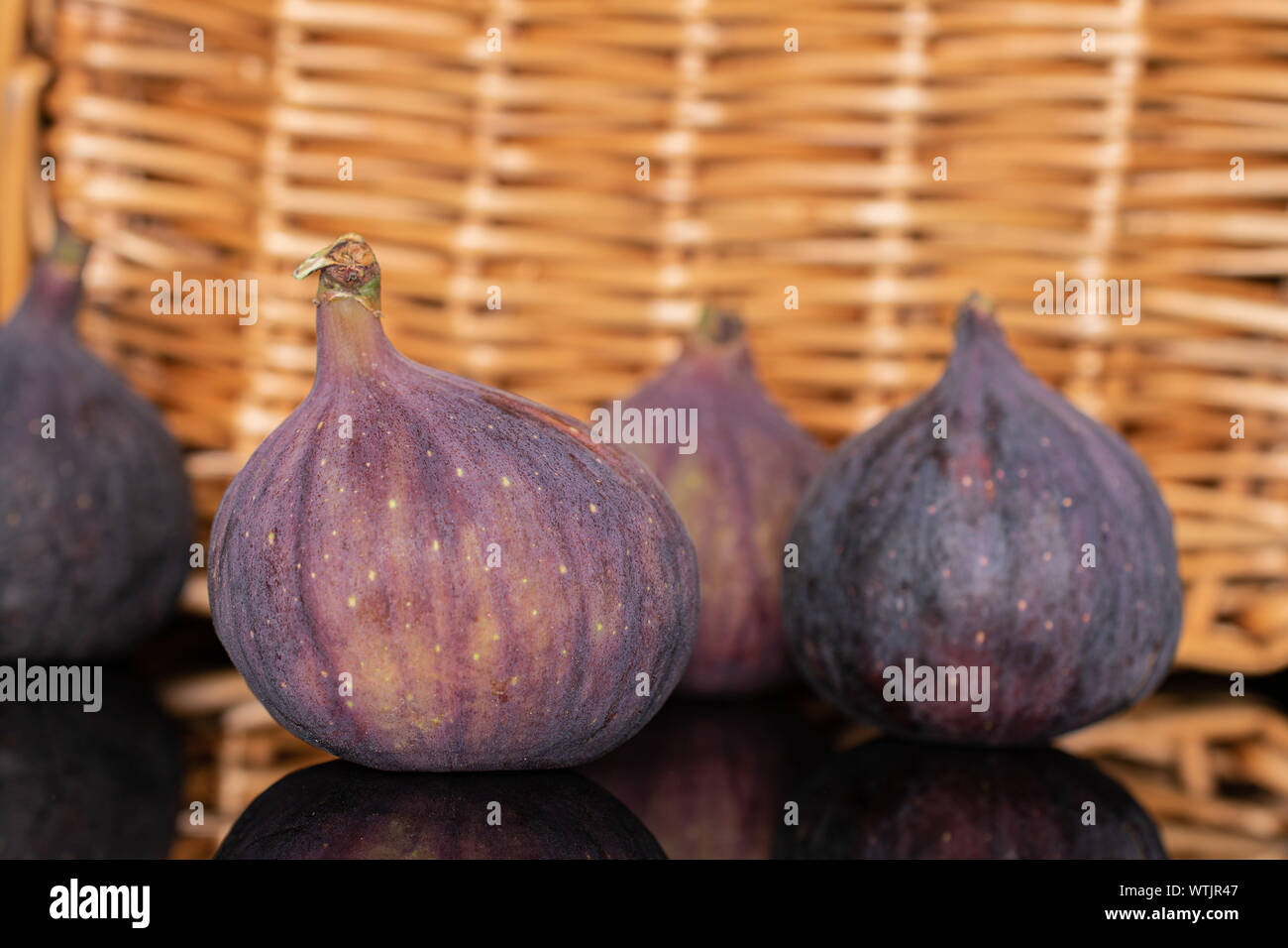 Group of four whole fresh fig fruit with braided rattan behind Stock ...