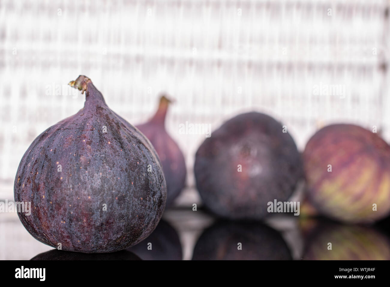 Group of four whole fresh fig fruit with white braided rattan Stock ...