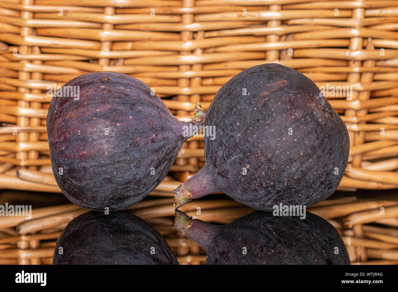 Group of two whole fresh fig fruit with braided rattan behind Stock ...