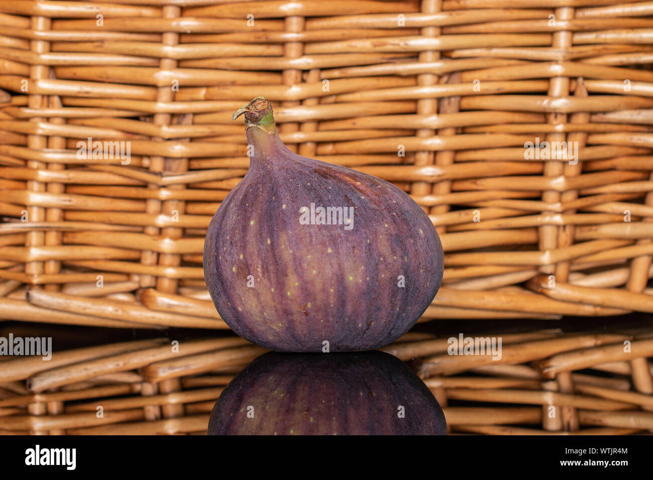 One whole fresh fig fruit with braided rattan behind Stock Photo - Alamy