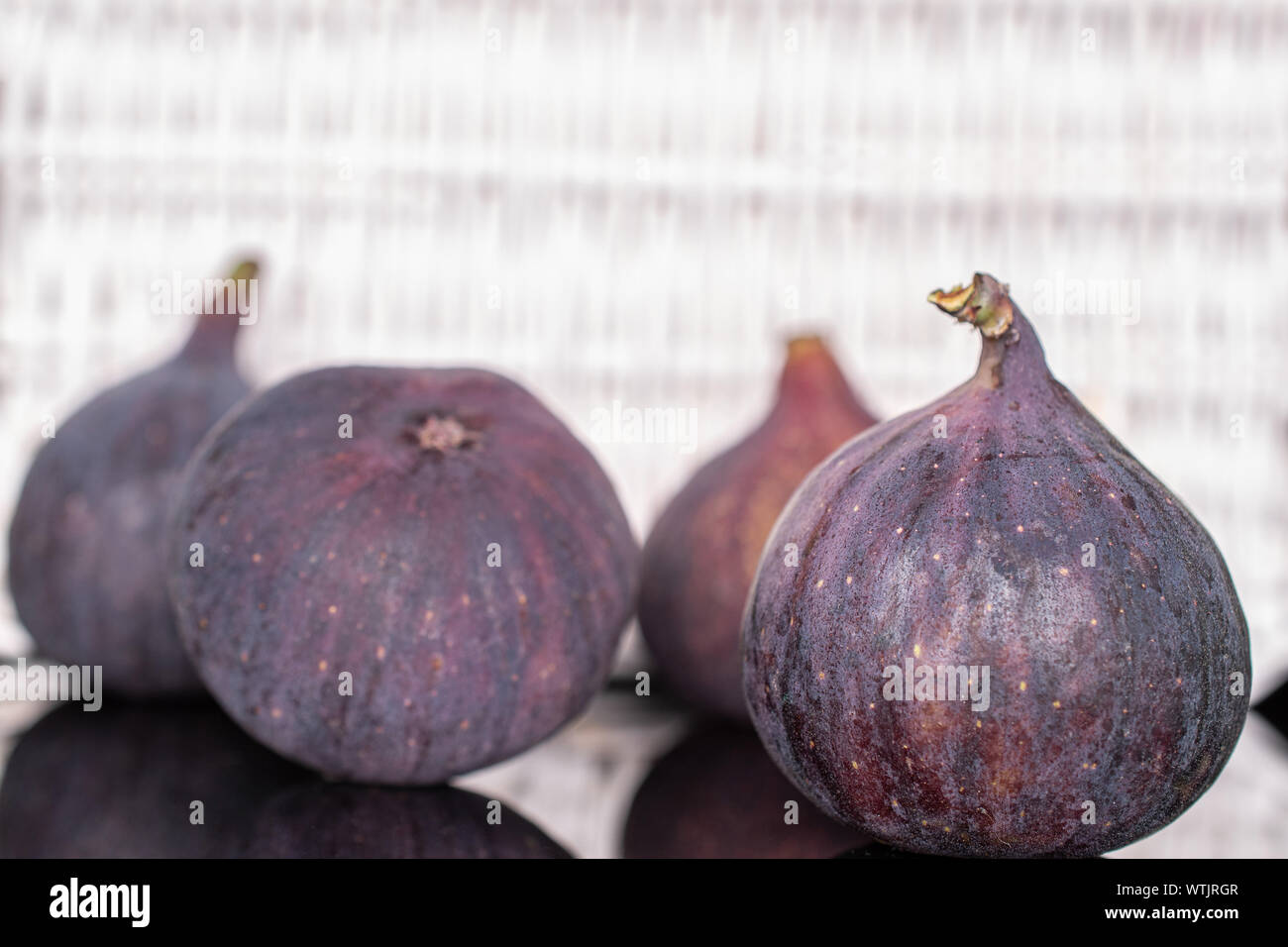 Group of four whole fresh fig fruit with white braided rattan Stock ...