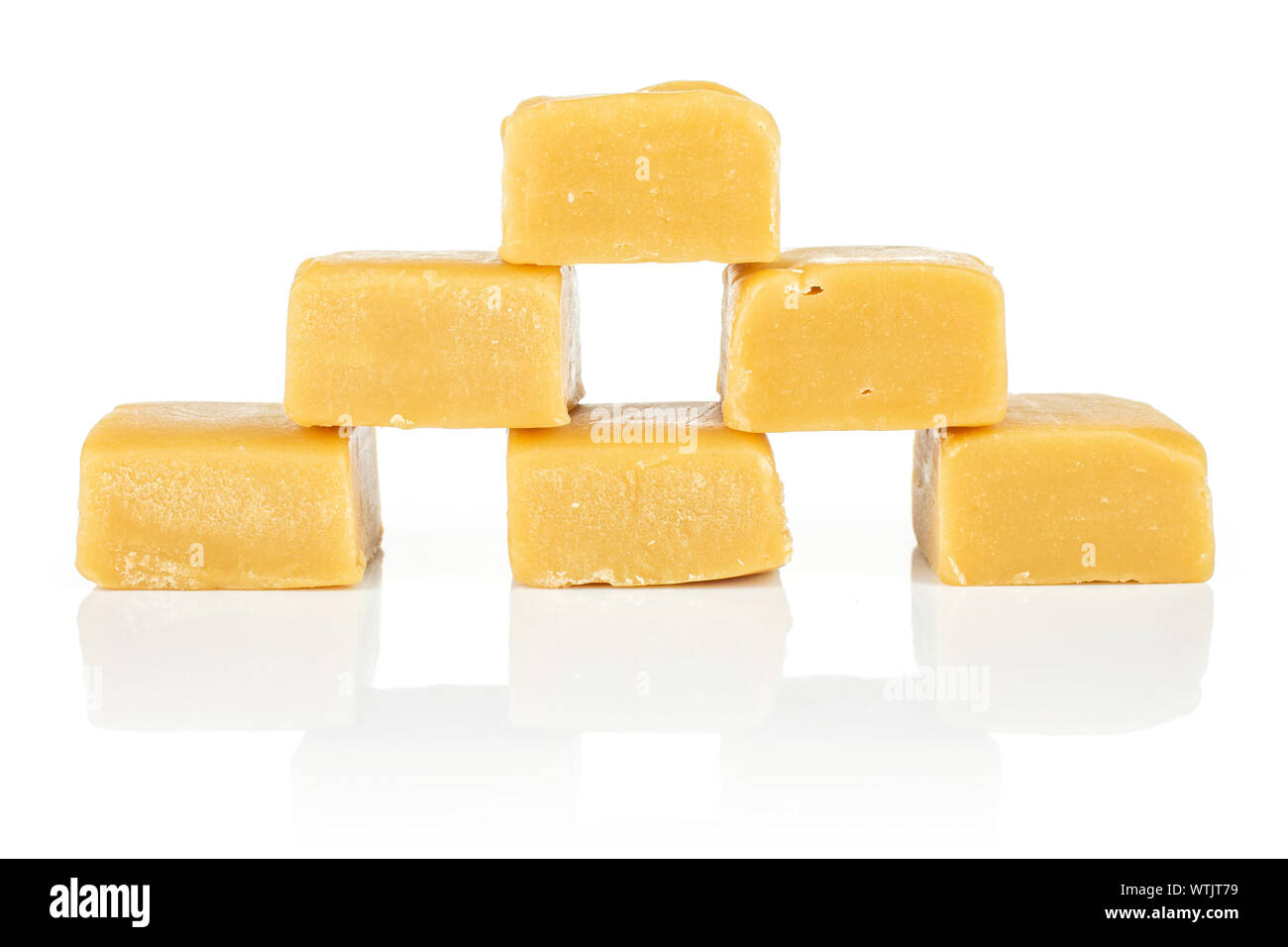 Group of six whole sweet golden caramel candy in pyramid isolated on ...