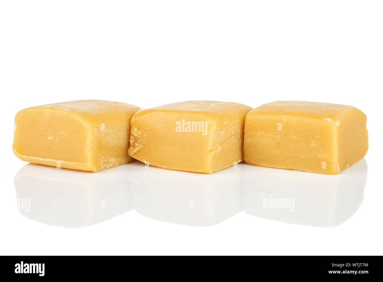 Group of three whole sweet golden caramel candy isolated on white ...