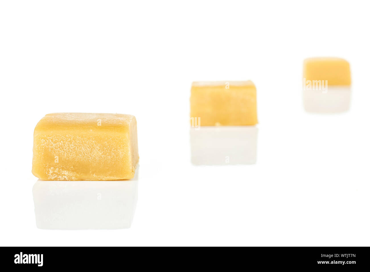 Group of three whole sweet golden caramel candy isolated on white ...