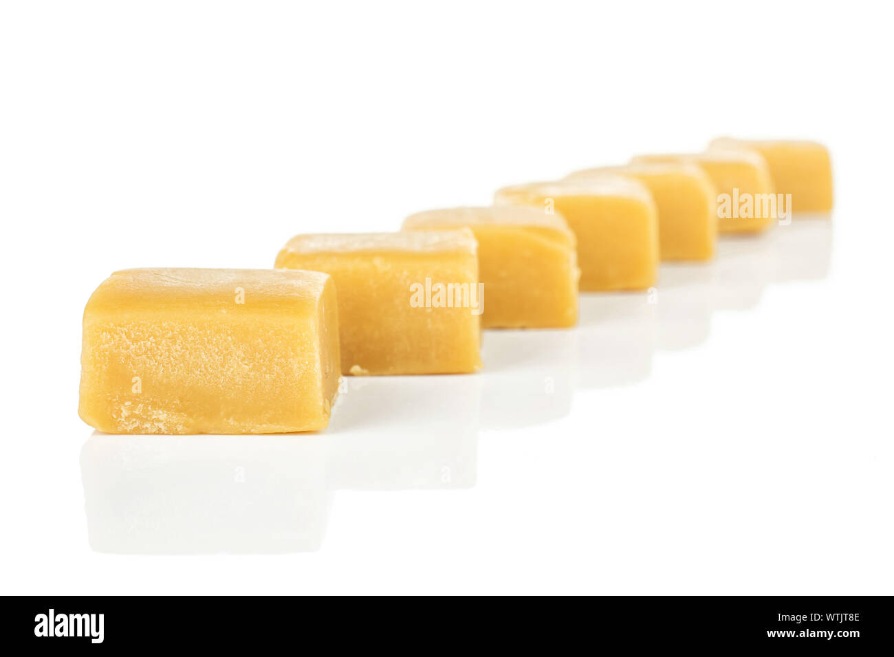 Group of seven whole sweet golden caramel candy isolated on white ...