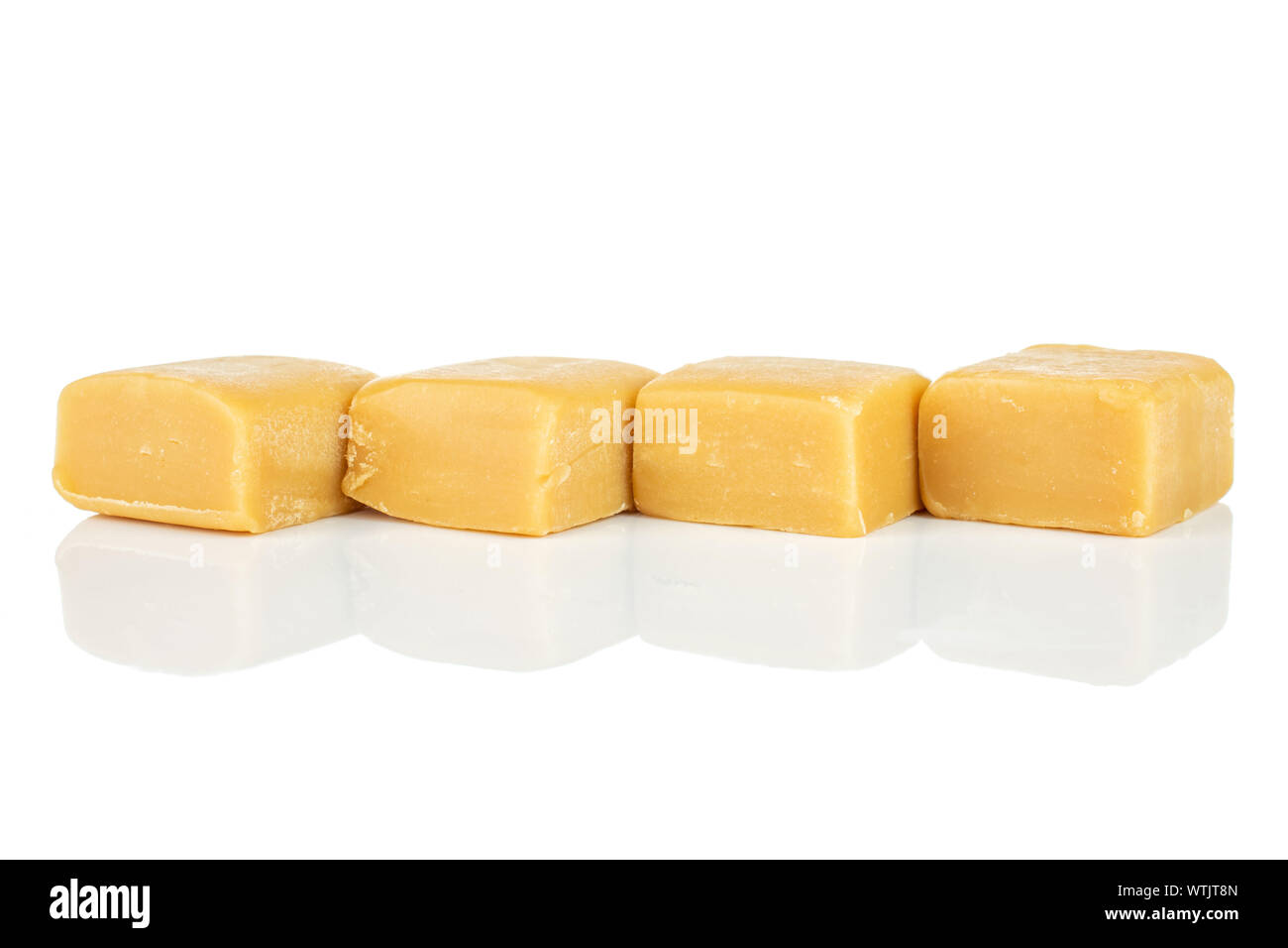 Group of four whole sweet golden caramel candy isolated on white ...