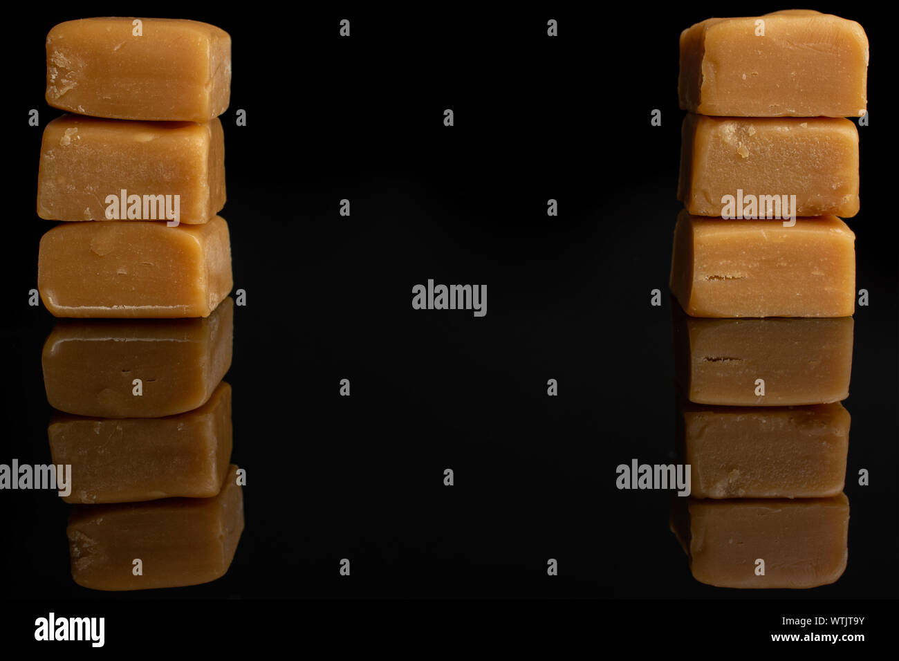 Group of six whole sweet golden caramel candy in two columns isolated ...