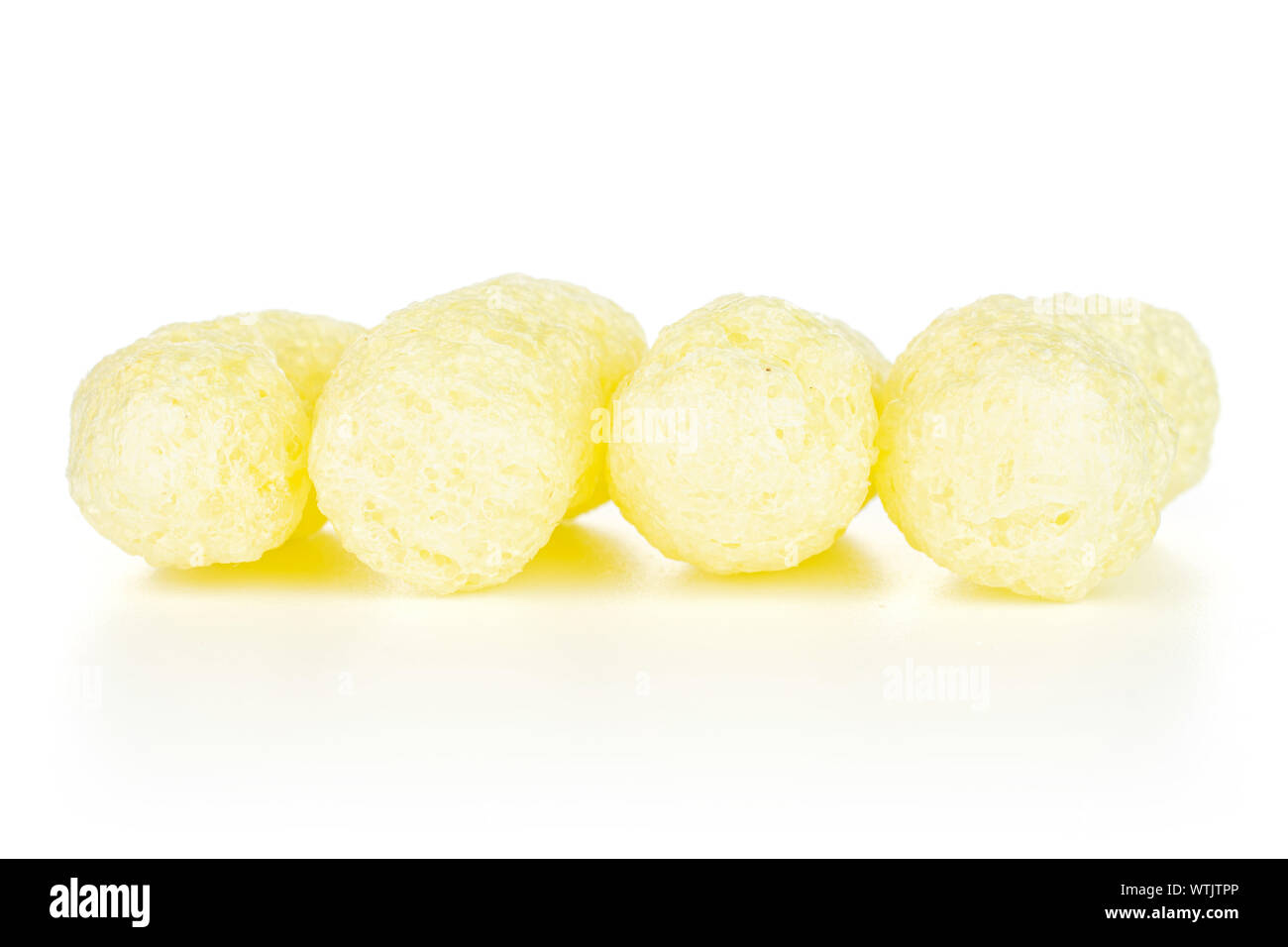 Group of four whole salted yellow corn puff isolated on white ...