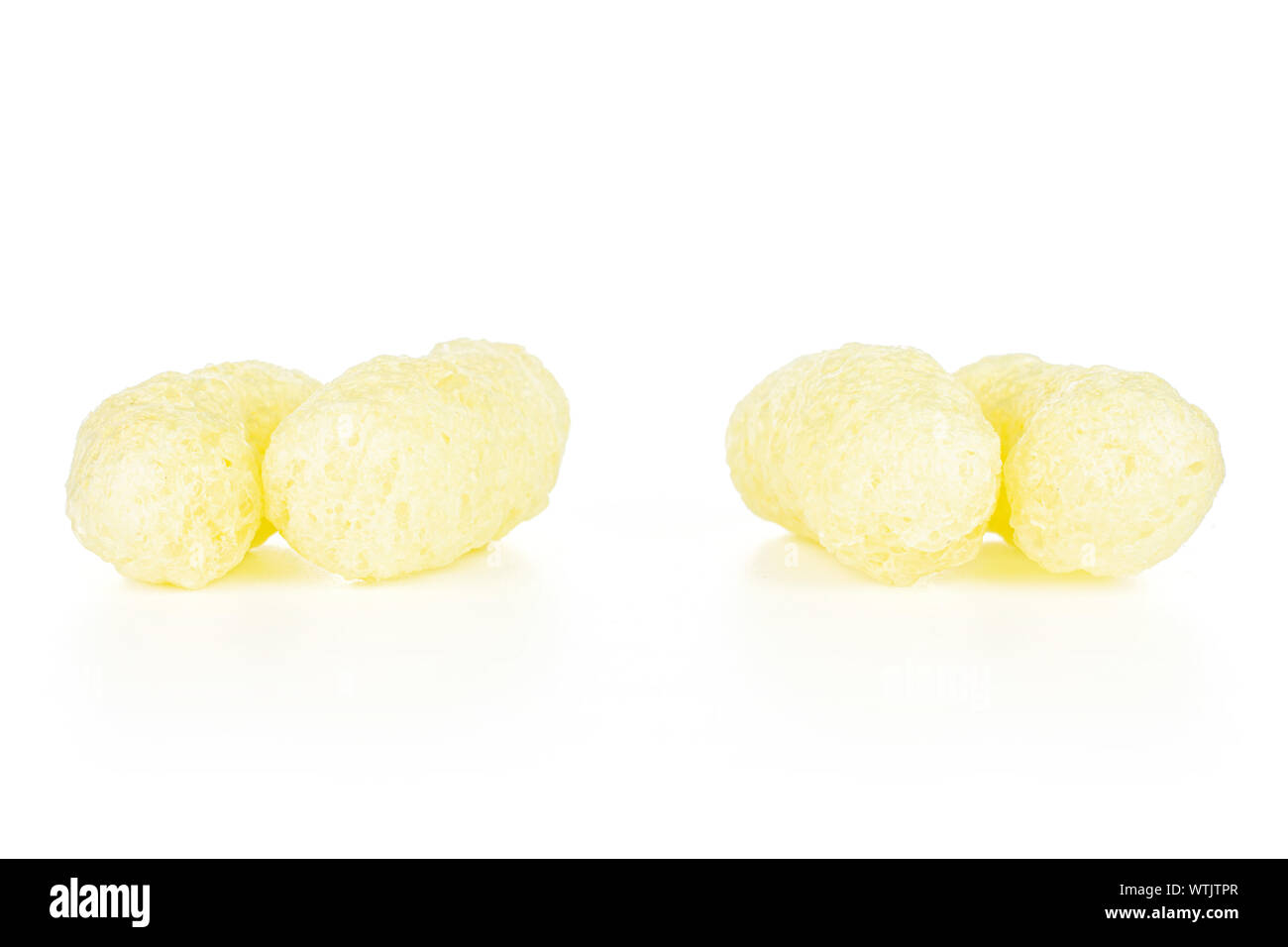 Group of four whole salted yellow corn puff isolated on white ...