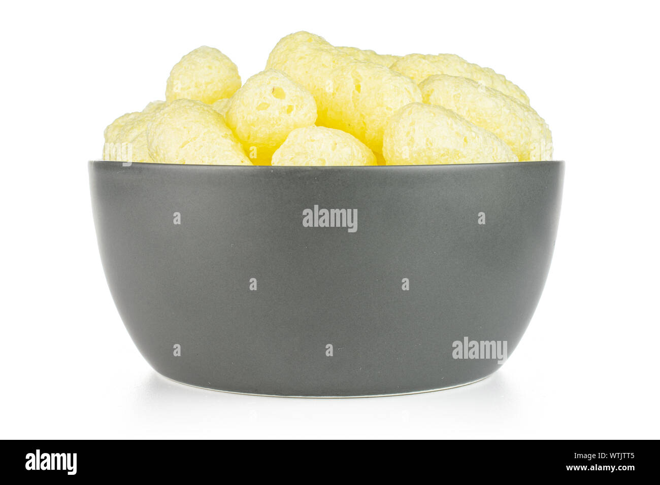 Lot of whole salted yellow corn puff in gray ceramic bowl isolated on ...