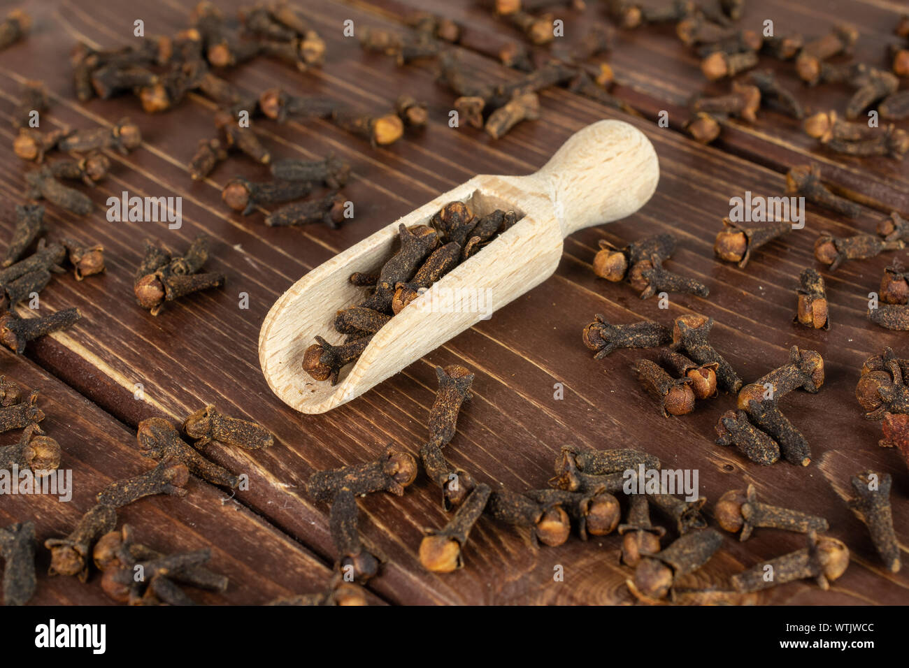 Lot of whole dry brown clove in a wooden scoop on brown wood Stock ...