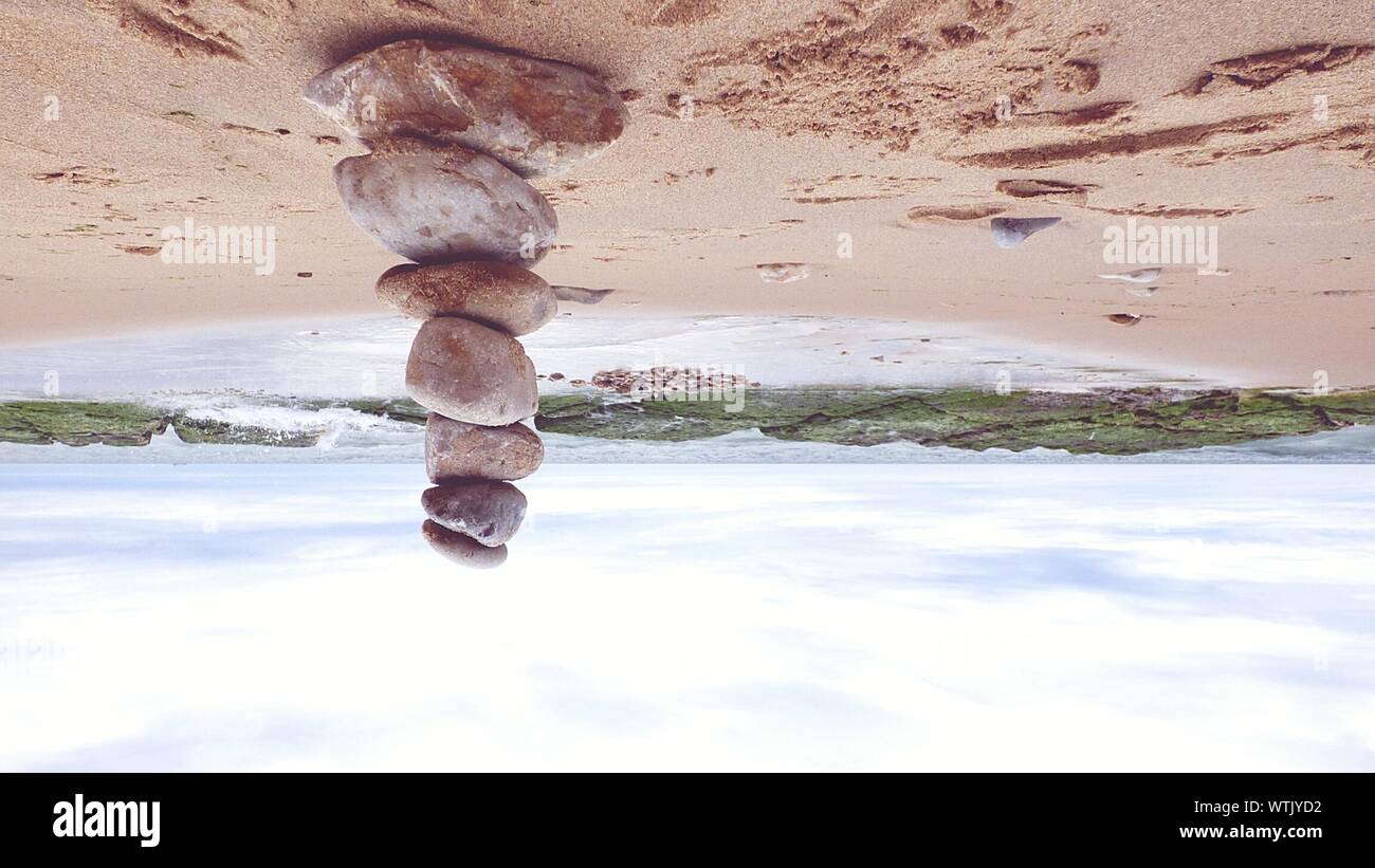 Upside Down Image Of Stacked Rocks At Sandy Beach Stock Photo - Alamy