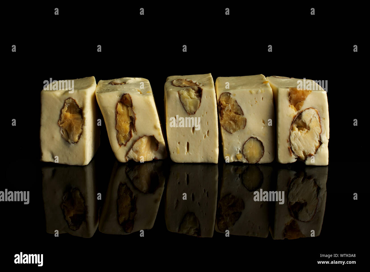 Group of five whole sweet white nougat isolated on black glass Stock ...