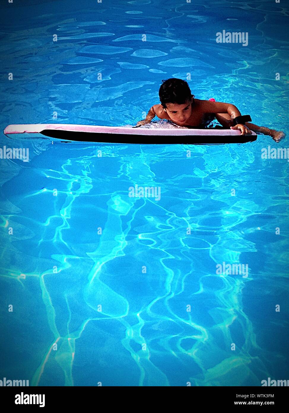 Boy on inflatable in pool hi-res stock photography and images - Alamy