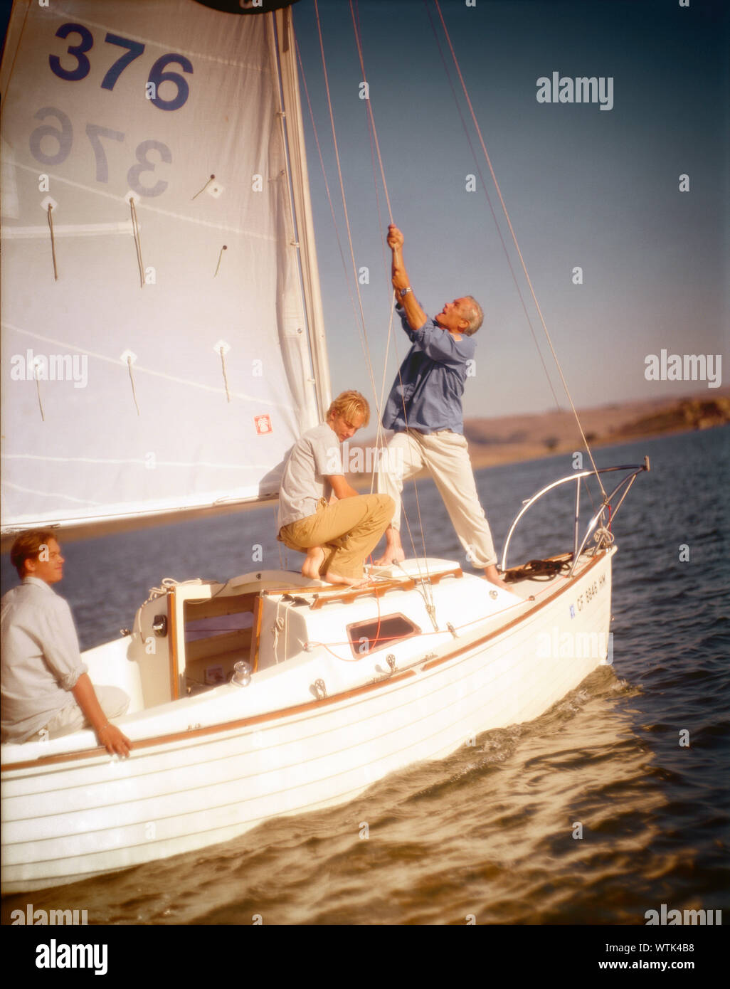 Three men on a boat in the sea Stock Photo - Alamy