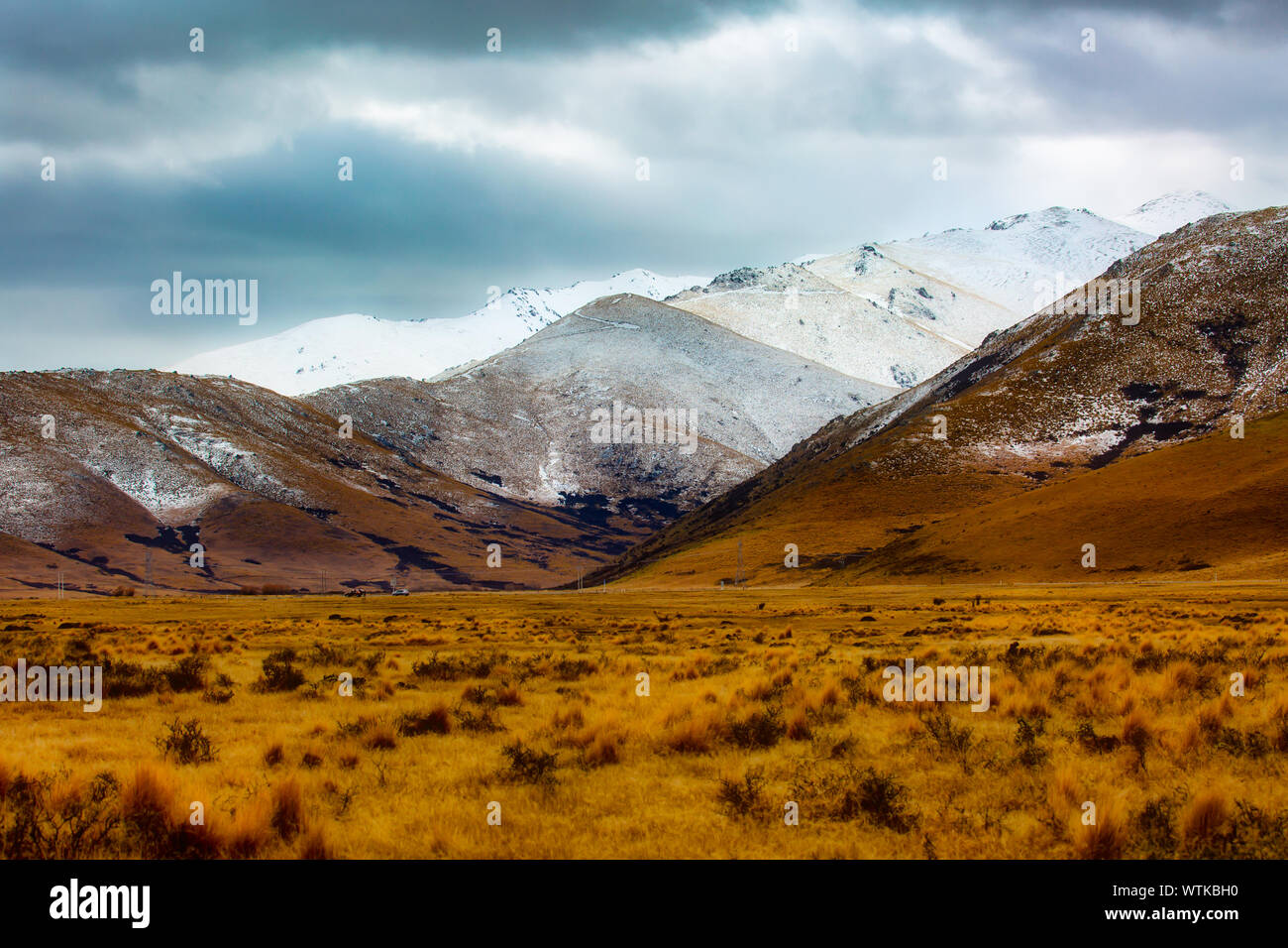 Extreme arid tundra terrain at the base of the snow dusted foothills of ...