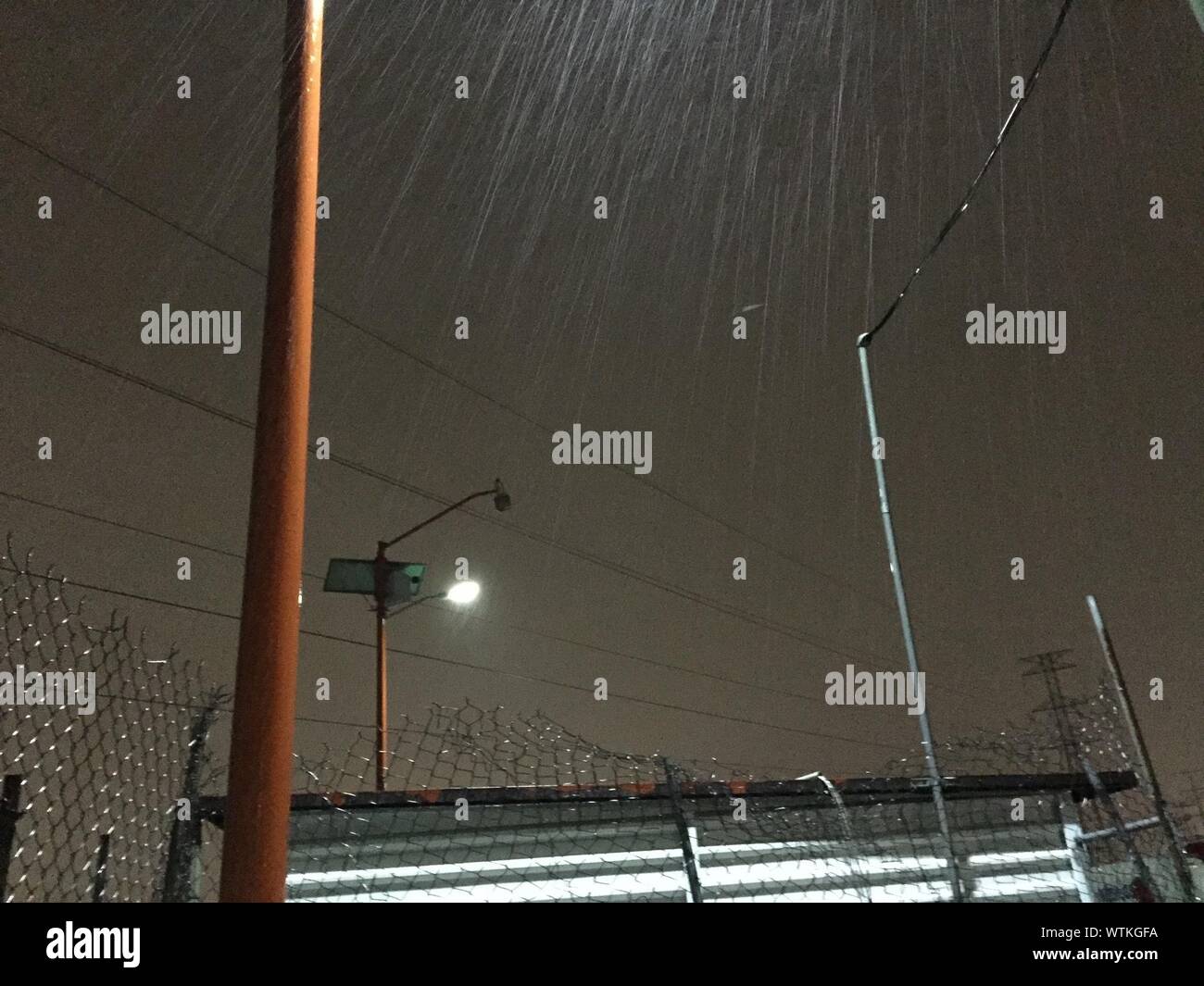 Chain Link Fence And Lampposts In Rain Stock Photo - Alamy