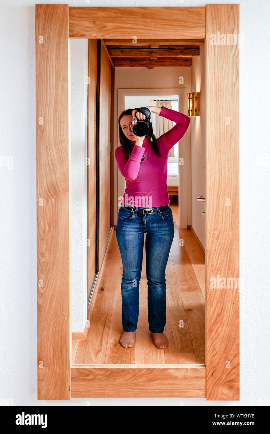 Mirror reflection of Young woman photographer with camera Stock Photo ...