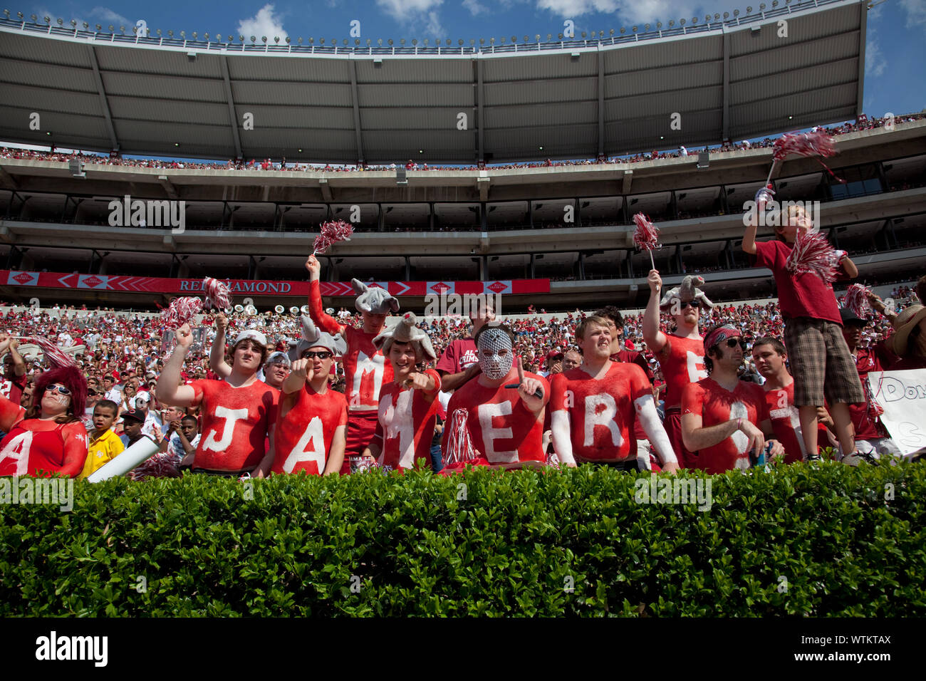 Most of the fans wear crimson and white with the name of the football ...