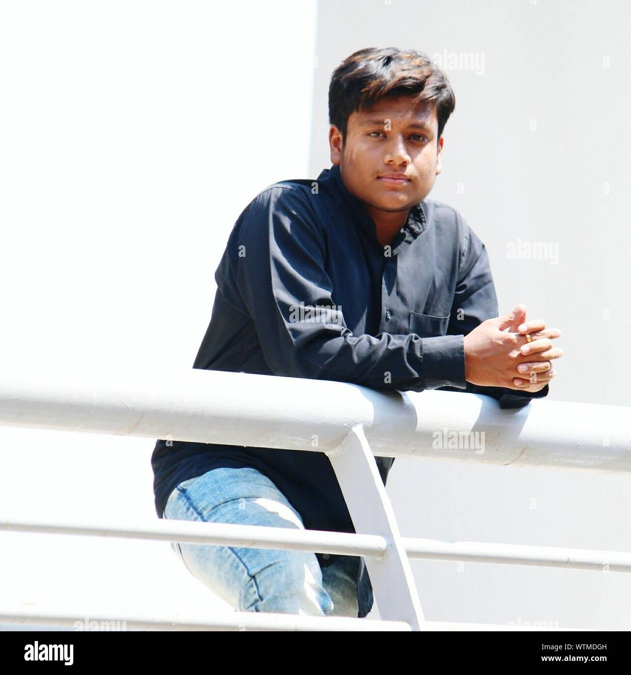 Low Angle Portrait Of Man Leaning On Railing At Balcony Stock Photo - Alamy