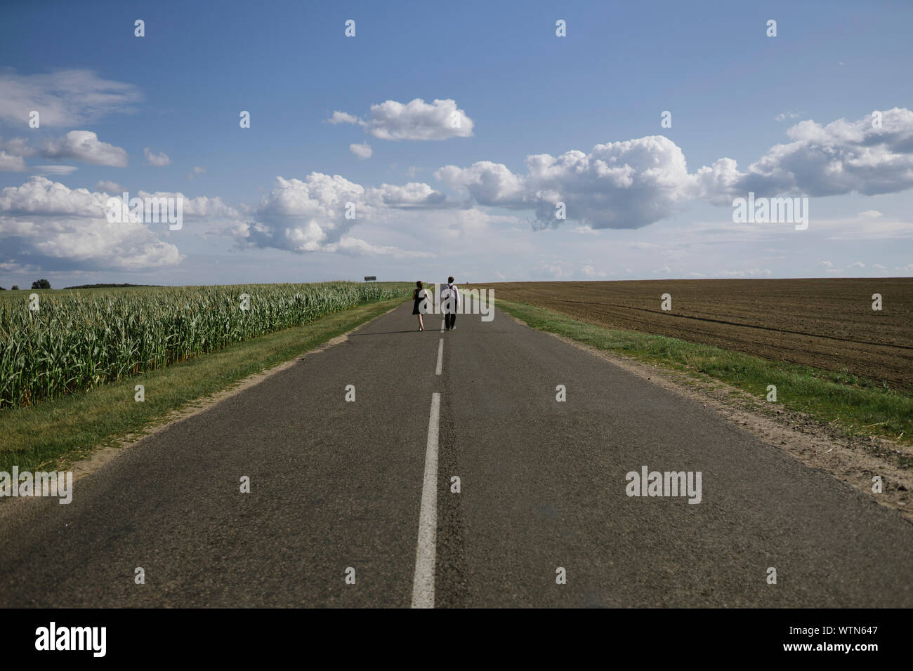 couple walking on the road holding hands Stock Photo - Alamy