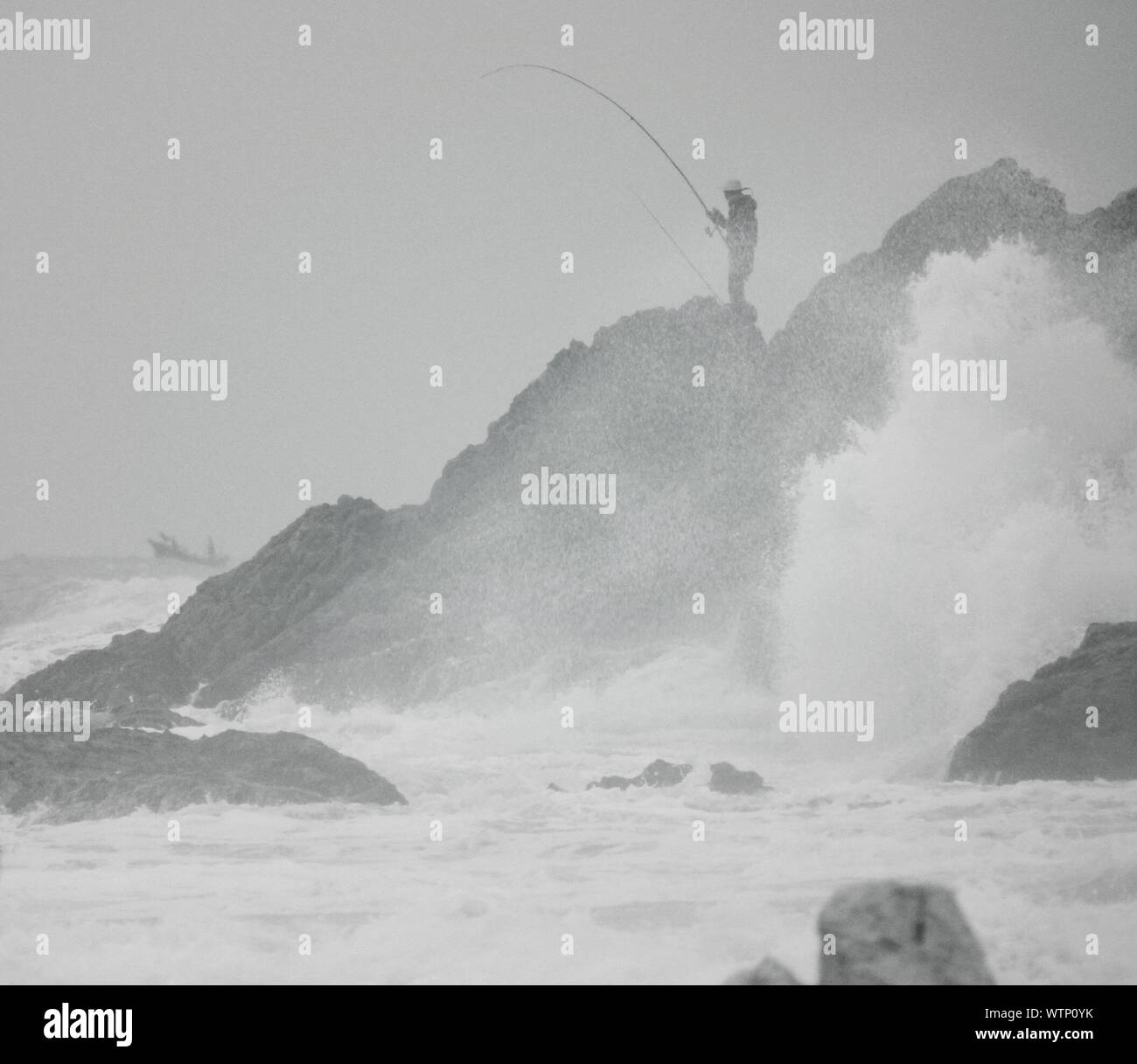 Side View Of Man Fishing In Sea At Dusk Stock Photo - Alamy