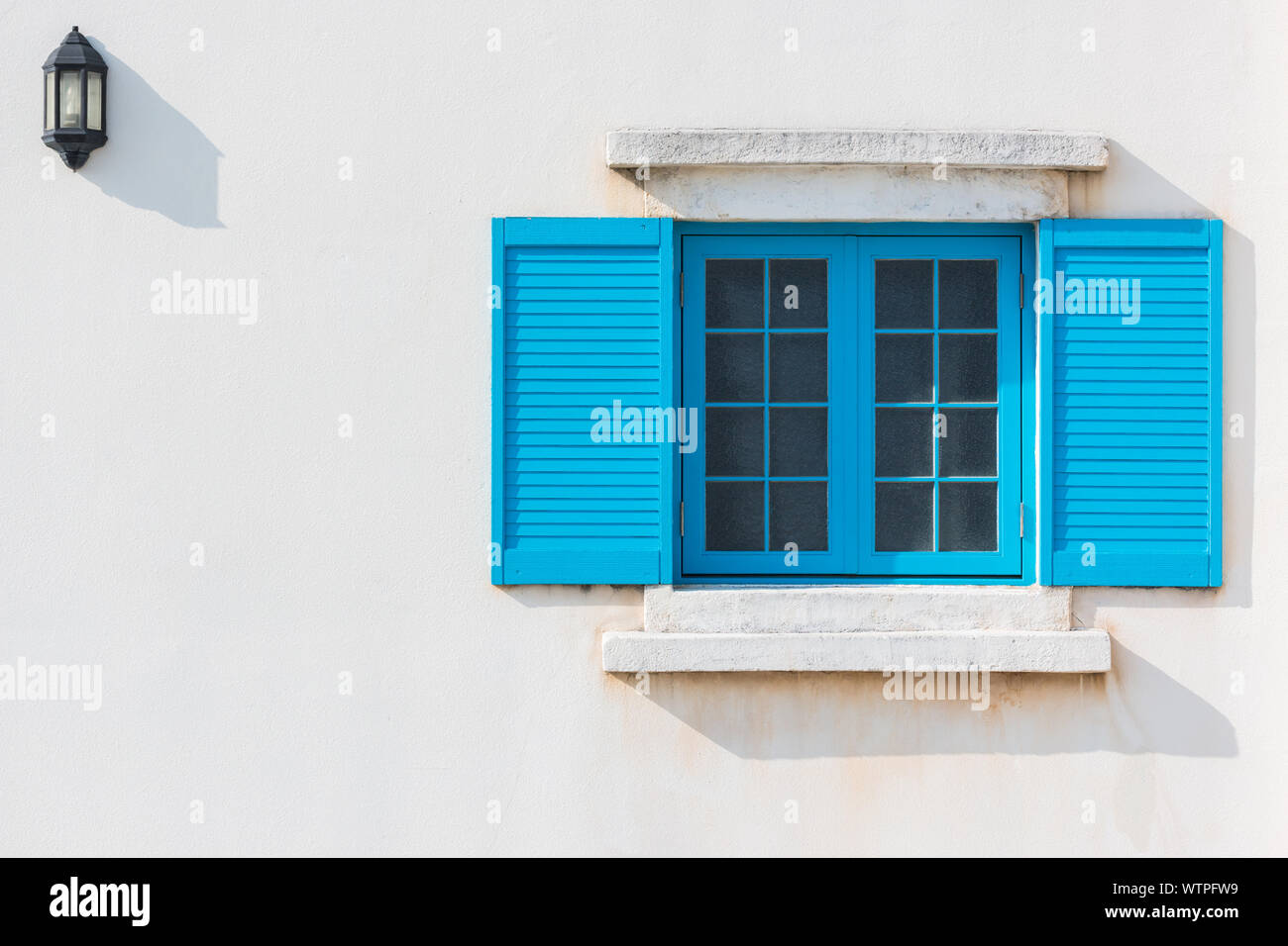 Colorful blue window and Detail of house exterior on white wall Stock ...