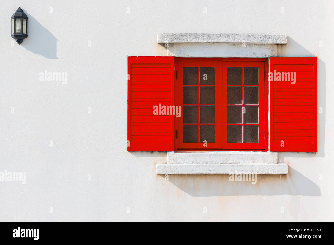 Colorful red window and Detail of house exterior on white wall Stock ...