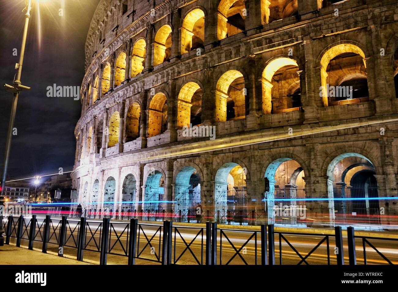 Light Trails On Street By Illuminated Coliseum At Night Stock Photo - Alamy