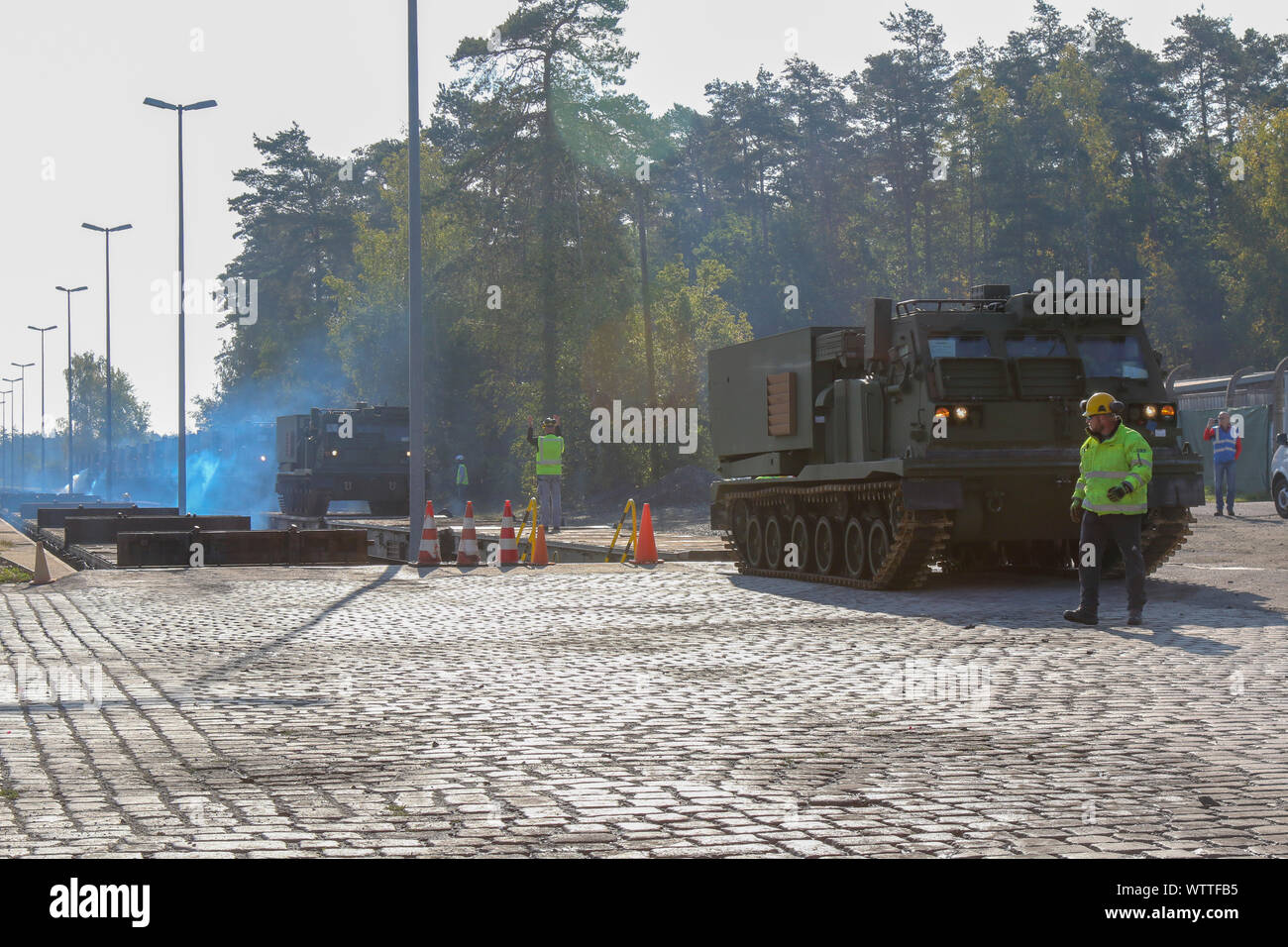 A contractor ground-guides military vehicles off of the Grafenwoehr ...