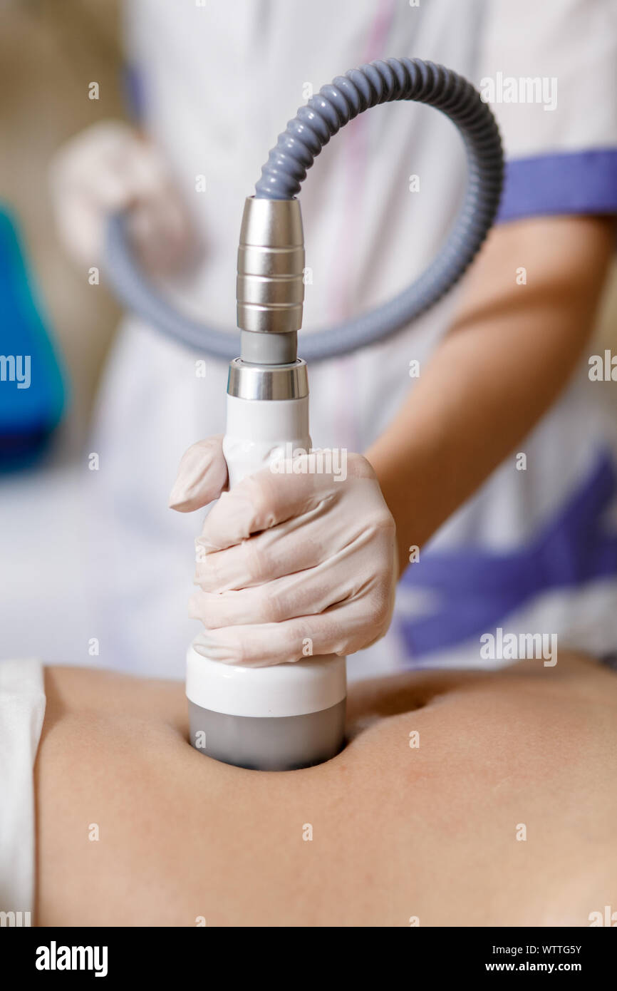 Vacuum massage device Anti cellulite body correction treatment. Loss weight apparatus. Woman and doctor at medicine salon. Beauty saloon. vacuum massage of the abdomen. Anticellulite massage Stock Pho...