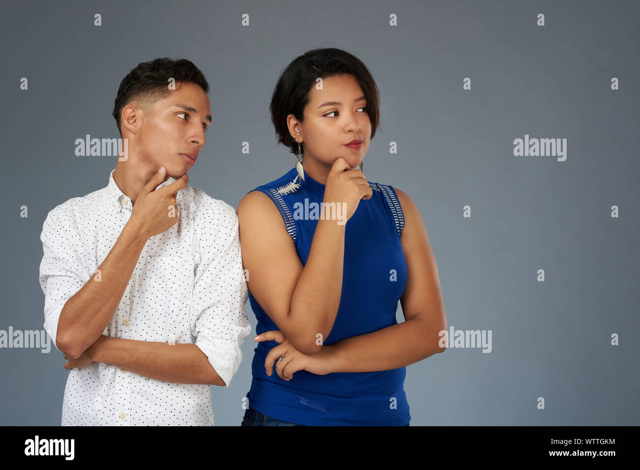 Young couple in thinking pose isolated on gray studio background Stock ...